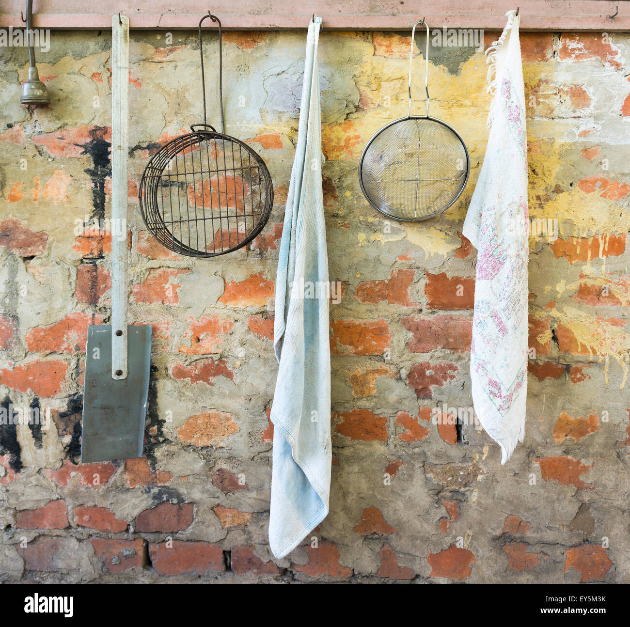 Rustic European inspired red brick wall with cooking utensils hanging ...