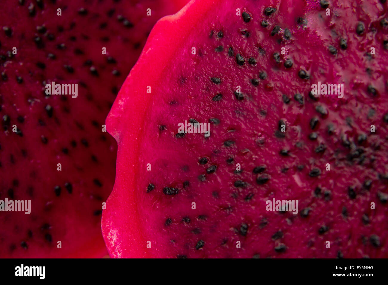 cut red dragon fruit with black seeds food background Stock Photo - Alamy
