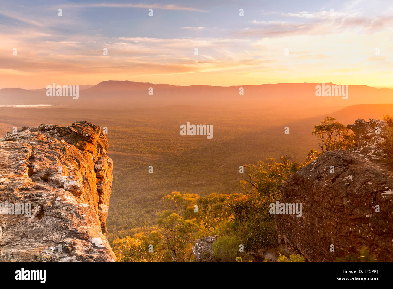 Mountain top views looking out over valley plain below in sunset light ...
