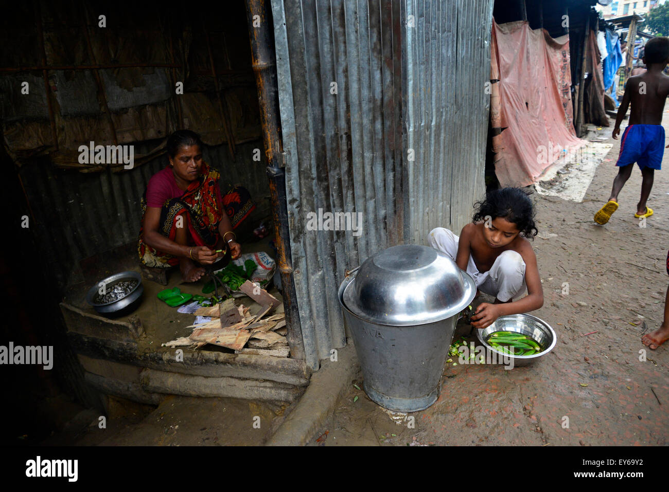 Dhaka, Bangladesh. 22nd July, 2015. A slum child cooking with her ...