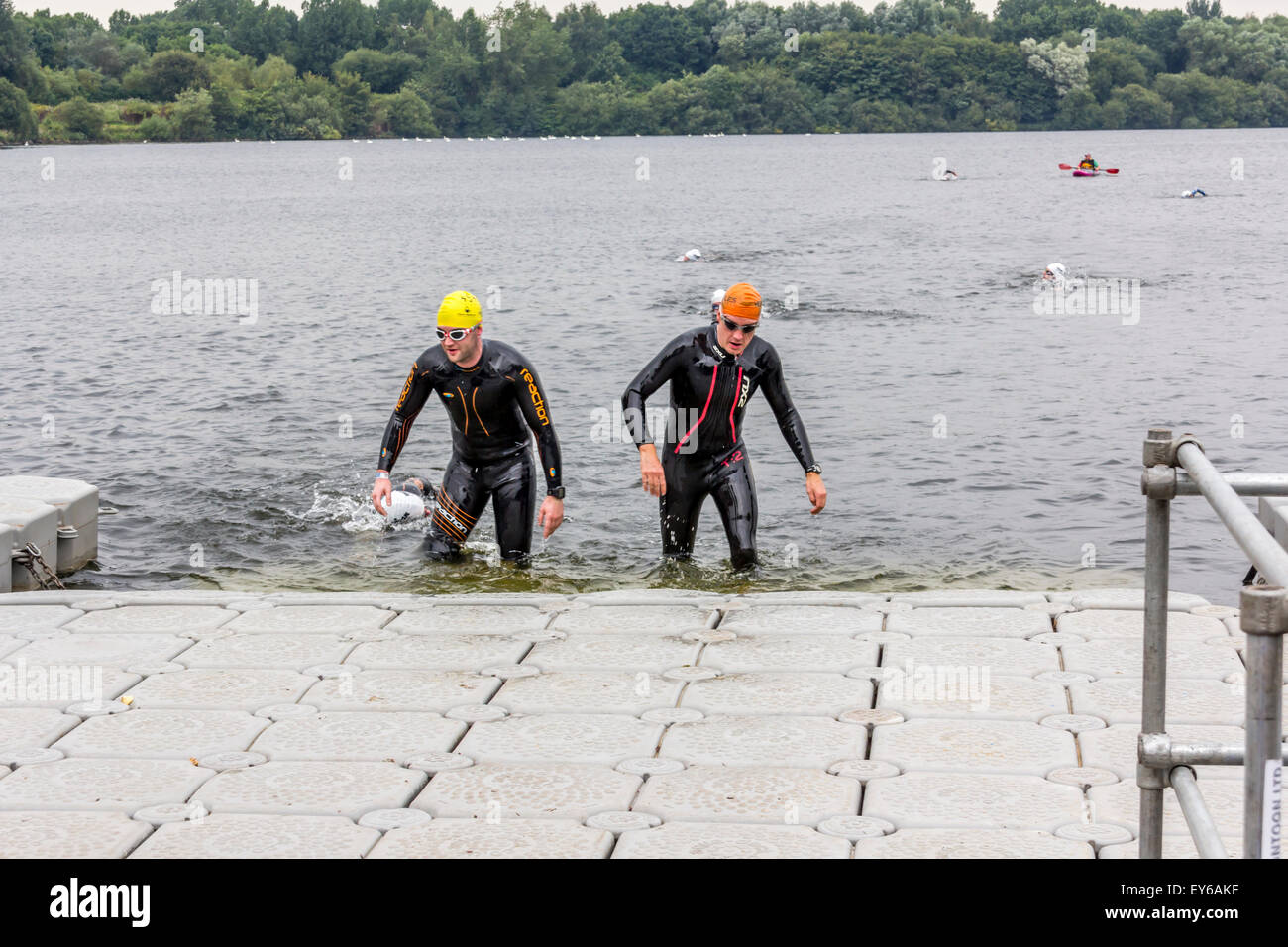two open water swimmers leaving the lake after completing their swim ...