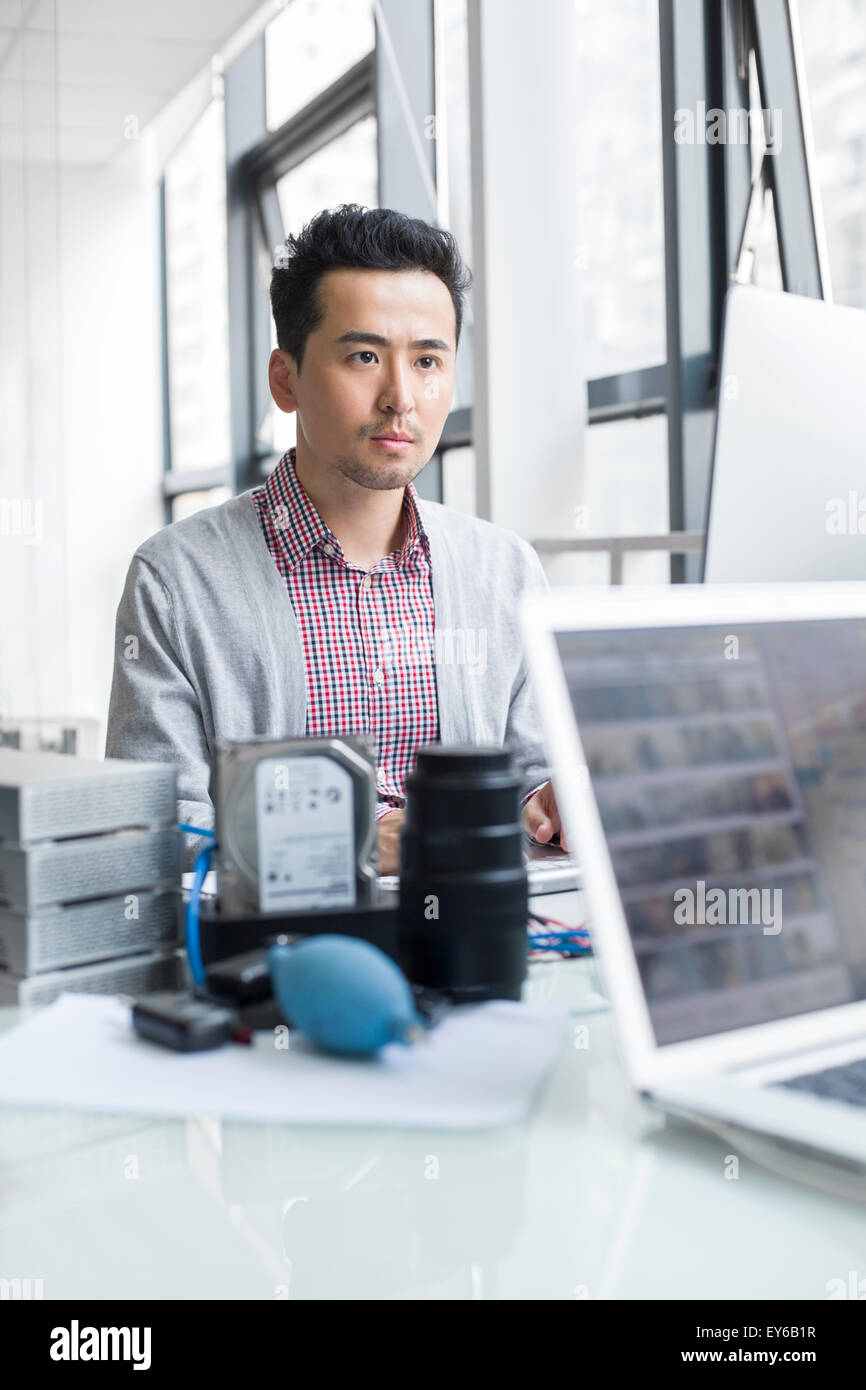 Male photographer working in office with computer Stock Photo - Alamy