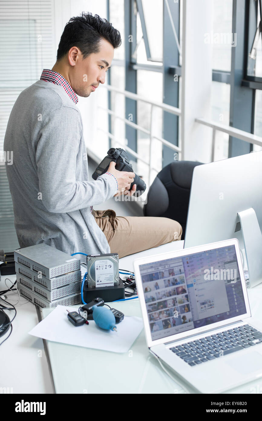 Male photographer working in office Stock Photo - Alamy