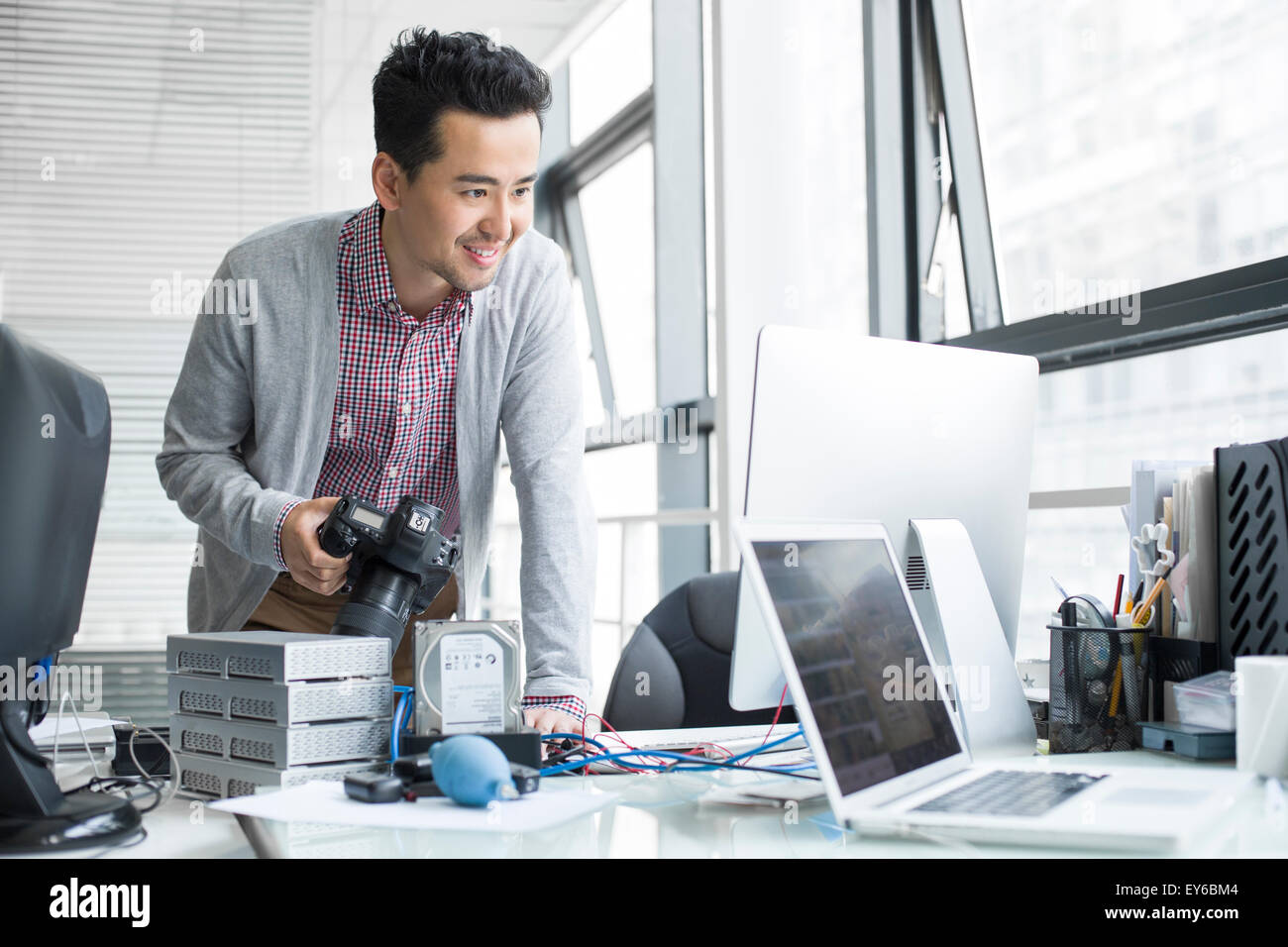 Male photographer working in office Stock Photo - Alamy