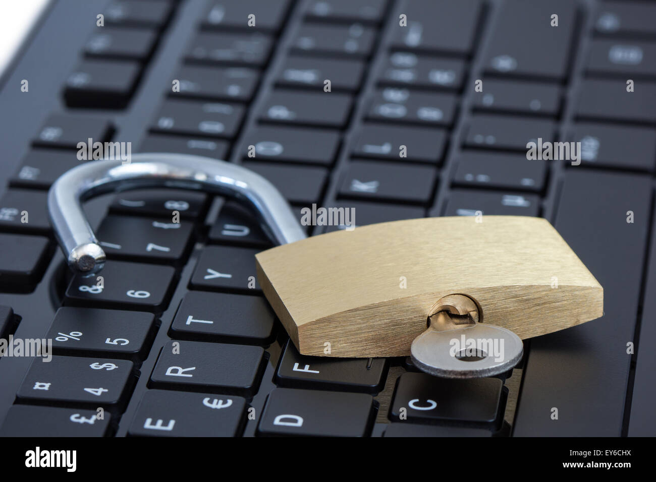 Close-up of a key in an unlocked padlock on a computer keyboard ...