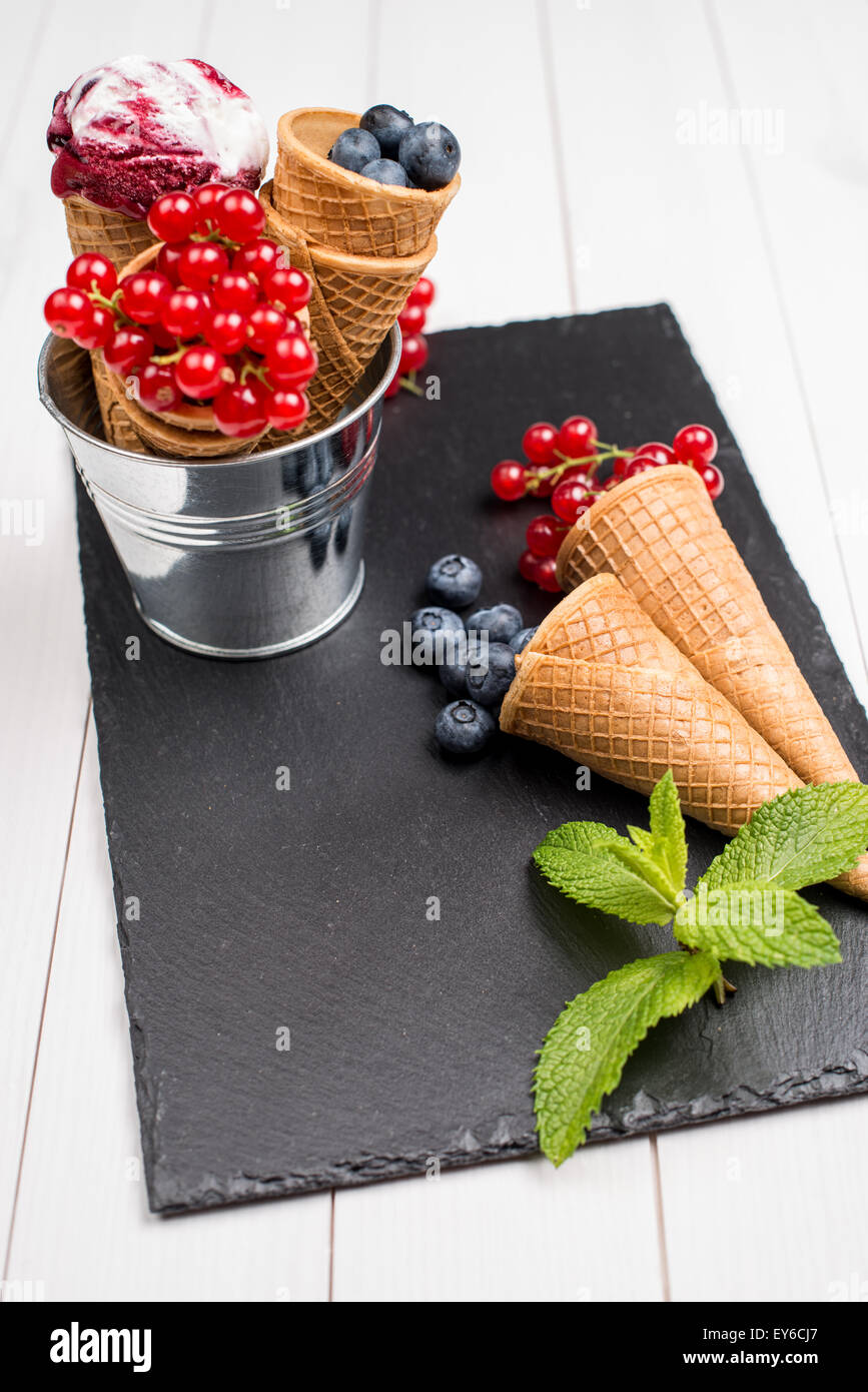 Red fruits ice cream cone on black slate board Stock Photo - Alamy