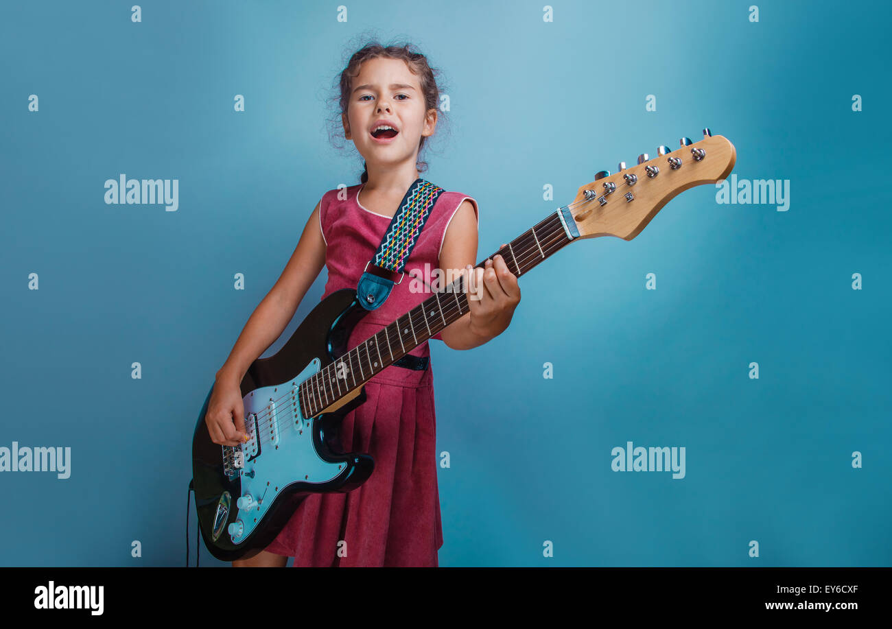 Girl European appearance ten years playing guitar sings on a blu Stock ...