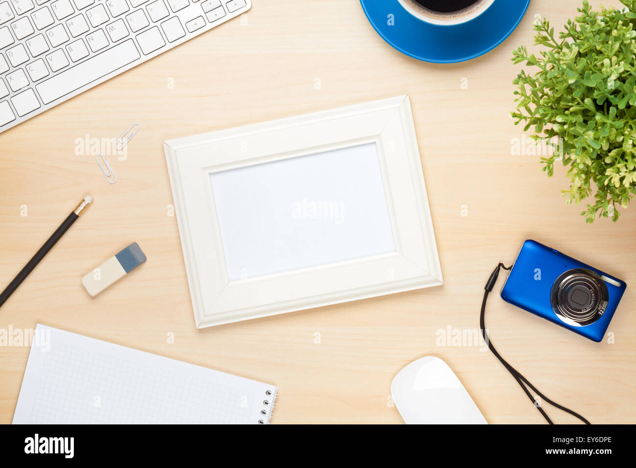 Photo frame on office table with notepad, computer and camera. View ...