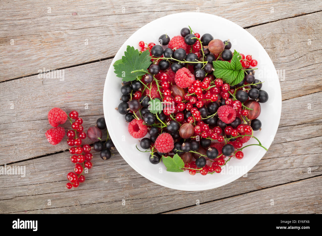 Fresh ripe berries plate on wooden table background Stock Photo - Alamy