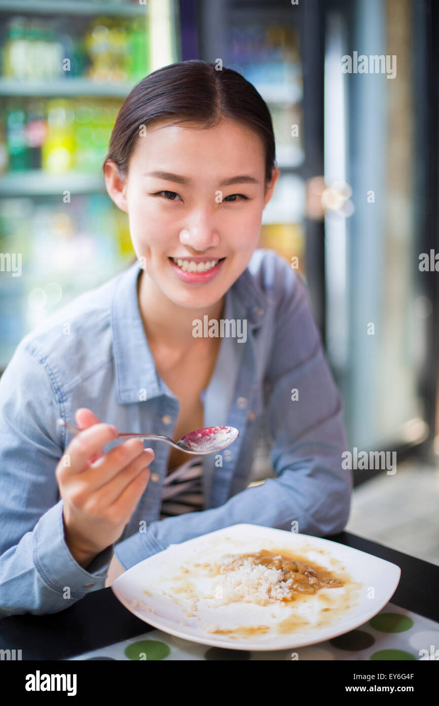 Young woman eating rice Stock Photo - Alamy