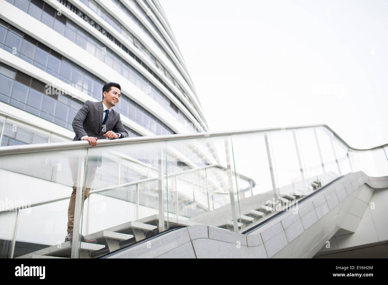 Businessman standing in front of office building Stock Photo - Alamy