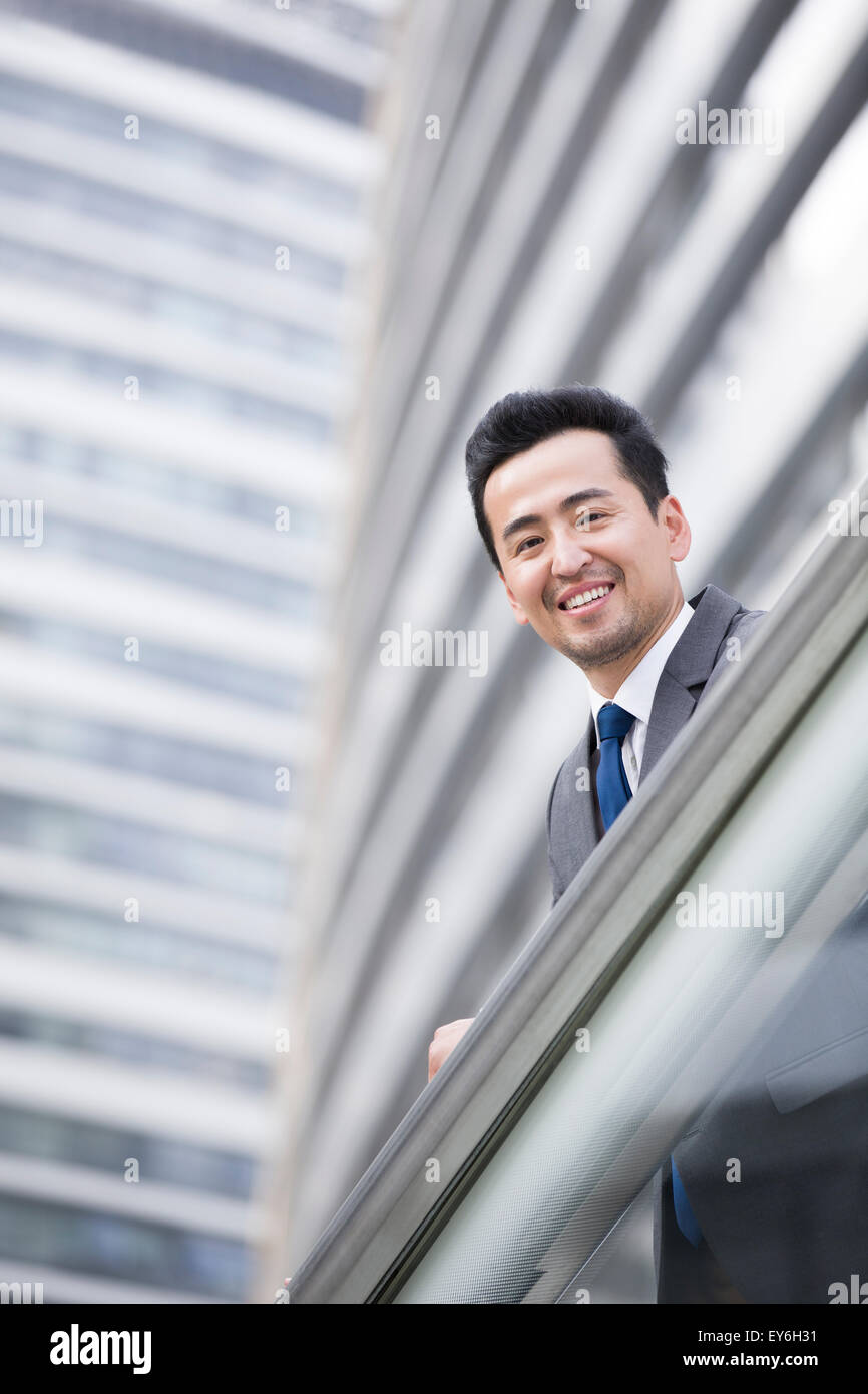 Businessman standing in front of office building Stock Photo - Alamy