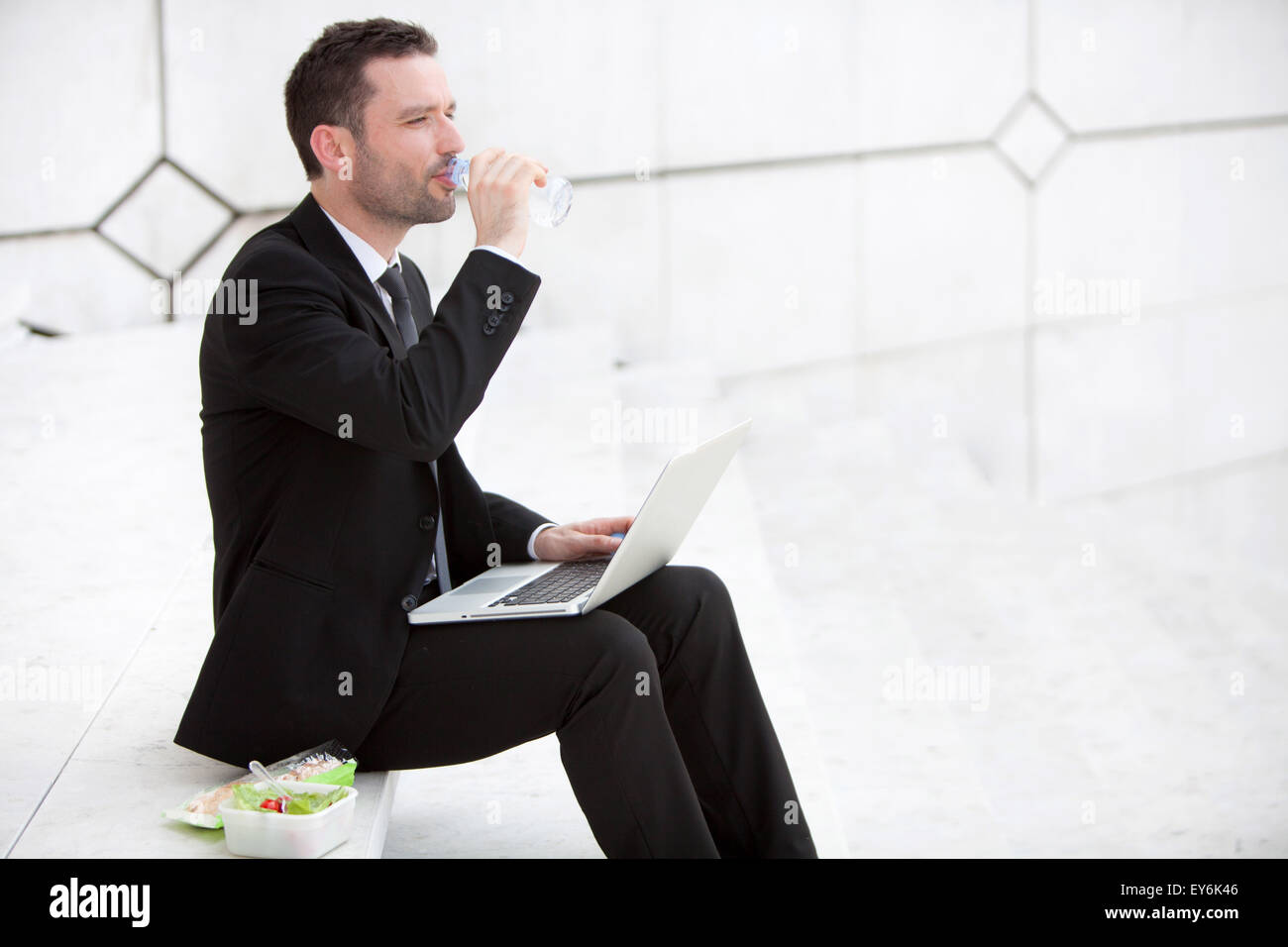 Attractive businessman keep working during lunch break Stock Photo - Alamy