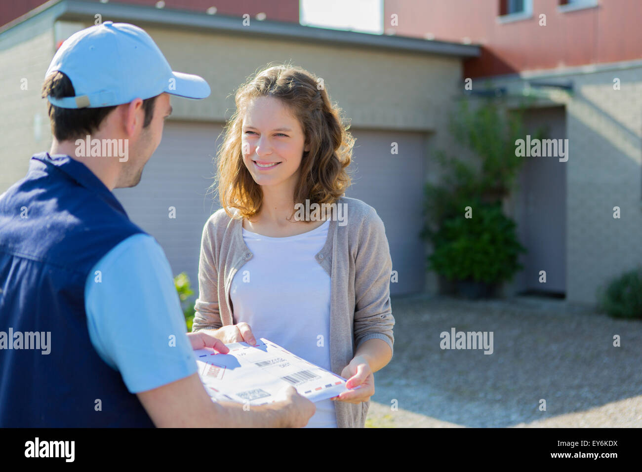 View of a Delivery man handing over a registered mail Stock Photo - Alamy