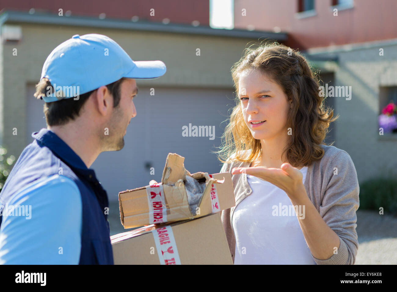 View of a Young attractive woman angry against delivery man Stock Photo ...