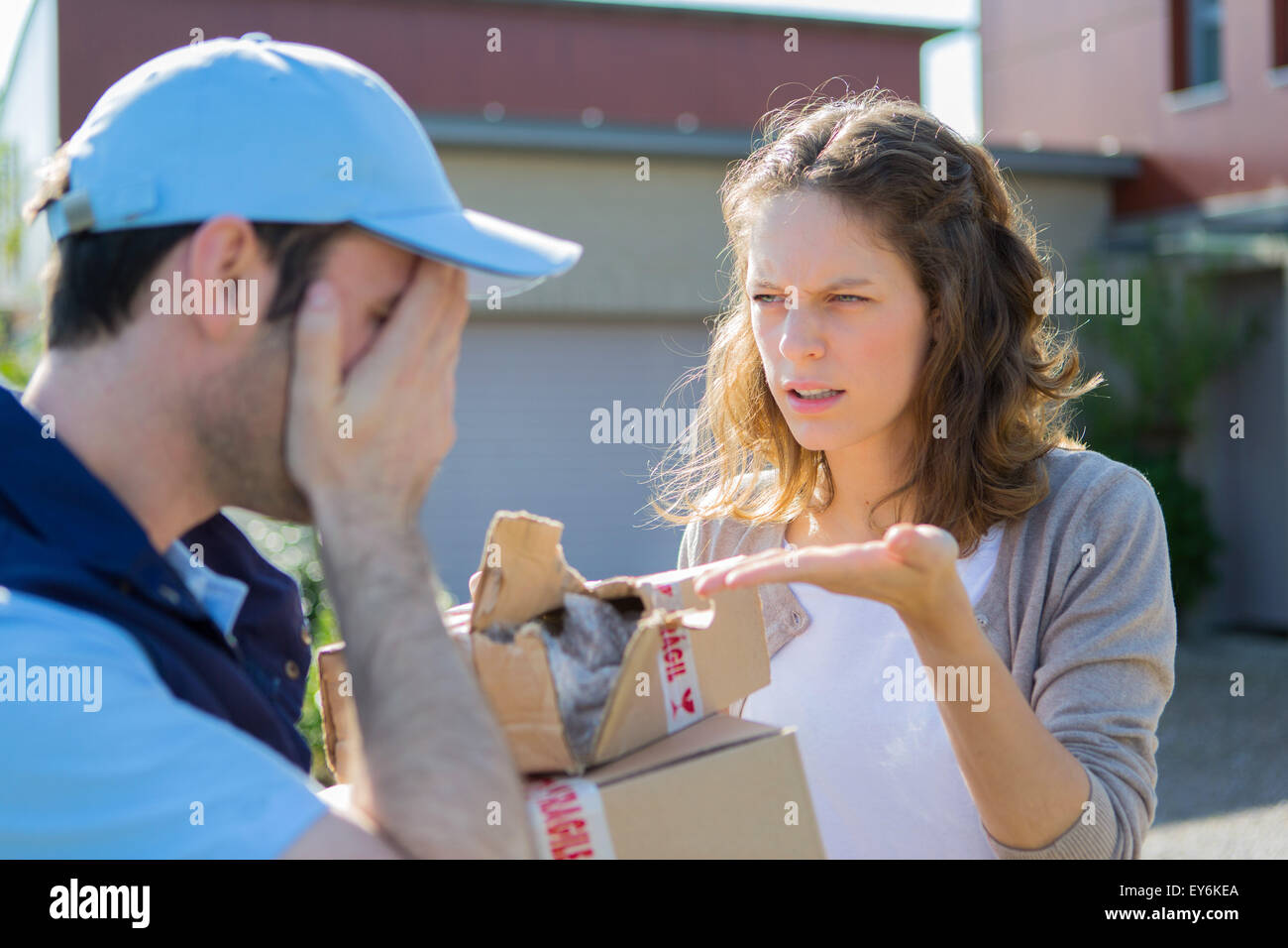 View of a Young attractive woman angry against delivery man Stock Photo ...
