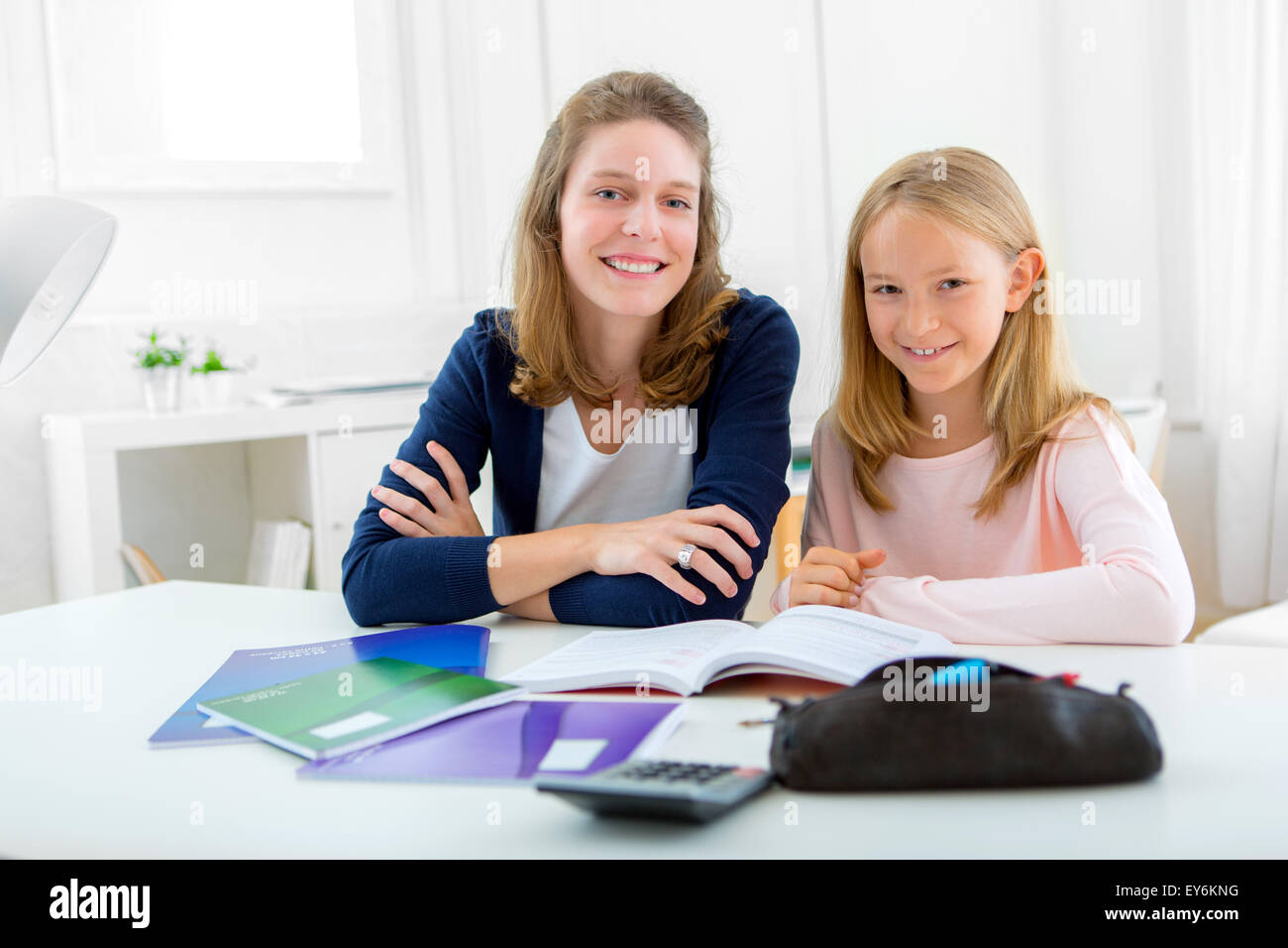 Portrait of a Woman helping out her little sister for homework Stock ...