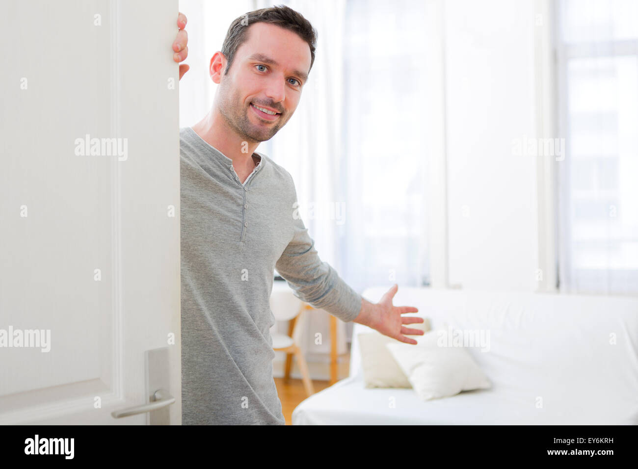 View of a Young attractive man welcoming you in his house Stock Photo ...