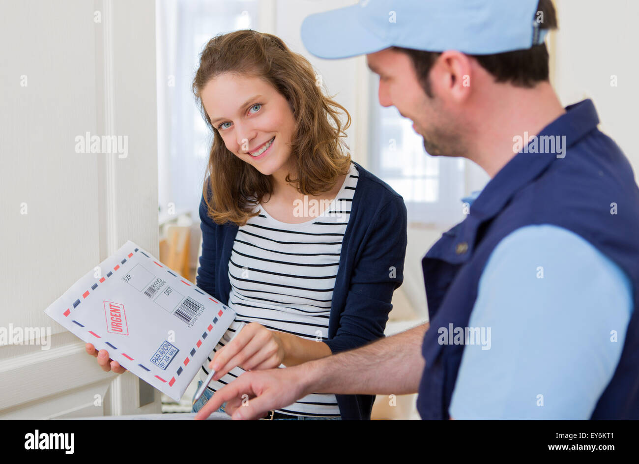 View of a Delivery man handing over a registered mail Stock Photo - Alamy