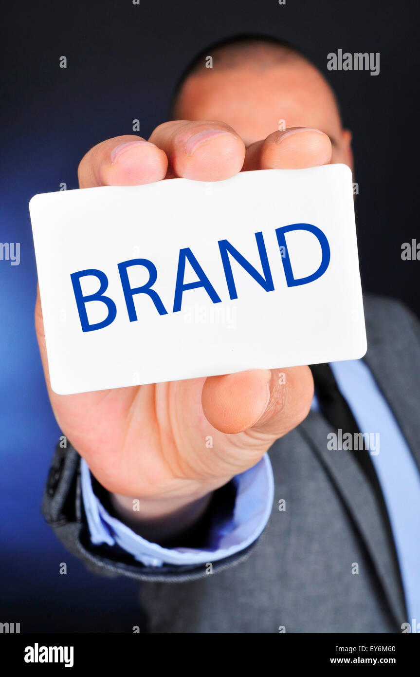 young caucasian man in suit shows a signboard with the word brand ...