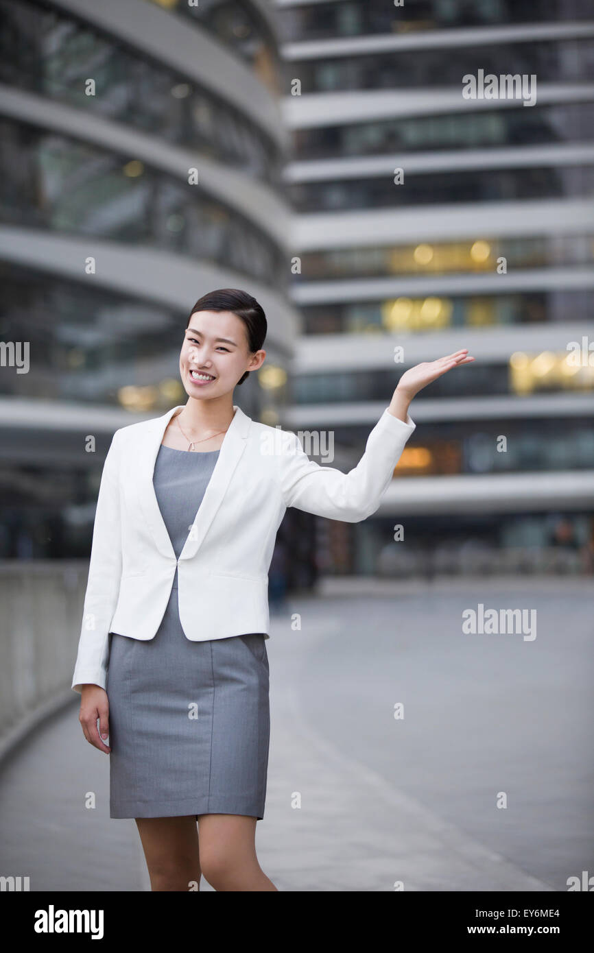 Businesswoman making a welcome gesture Stock Photo - Alamy
