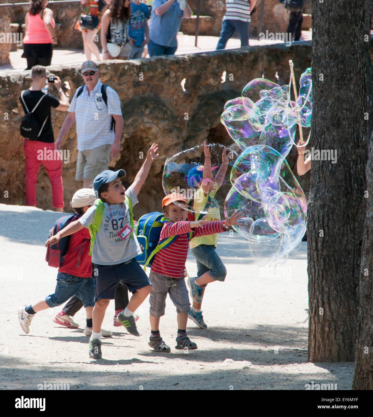 Children chasing giant bubbles created by street performer in Parc ...