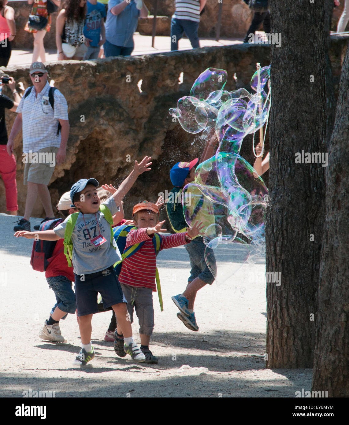 Children chasing giant bubbles created by street performer in Parc ...