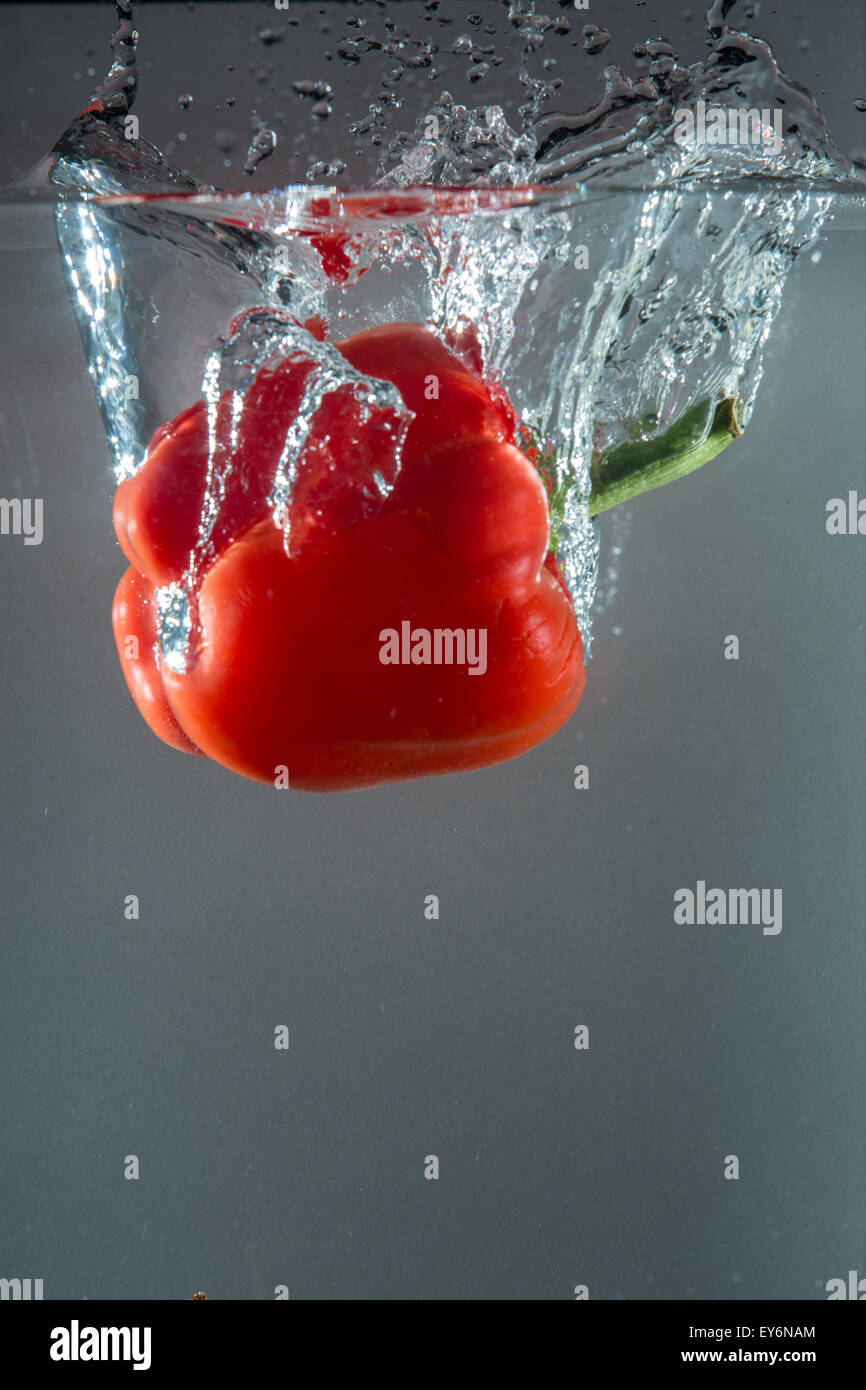 Vegetables in different colors, yellow and red, thrown into water to ...