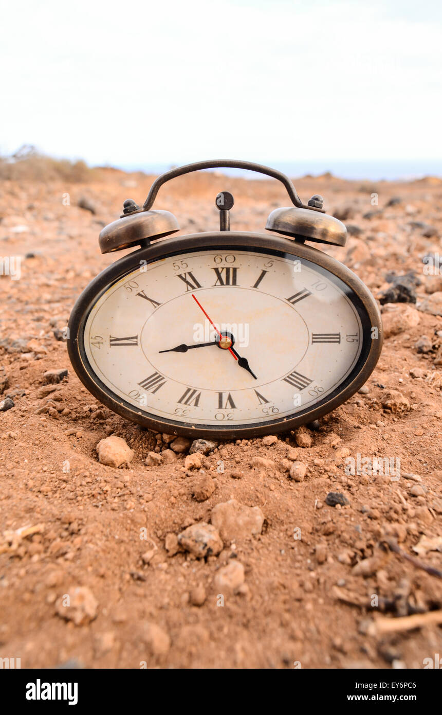 Classic Analog Clock In The Sand Stock Photo - Alamy