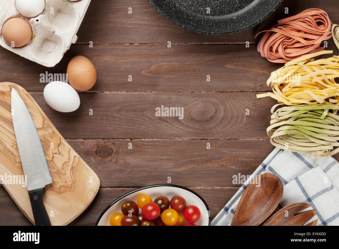 Pasta cooking ingredients and utensils on wooden table. Top view with ...
