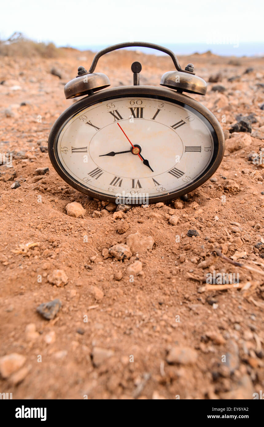 Classic Analog Clock In The Sand Stock Photo - Alamy