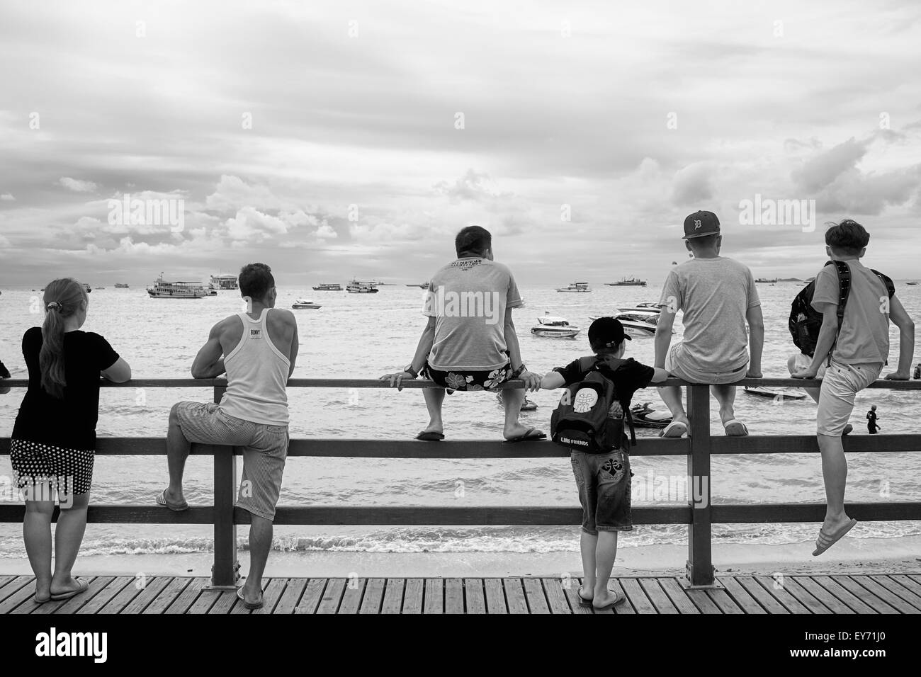 People sitting on the fence. Black and white photography Stock Photo ...