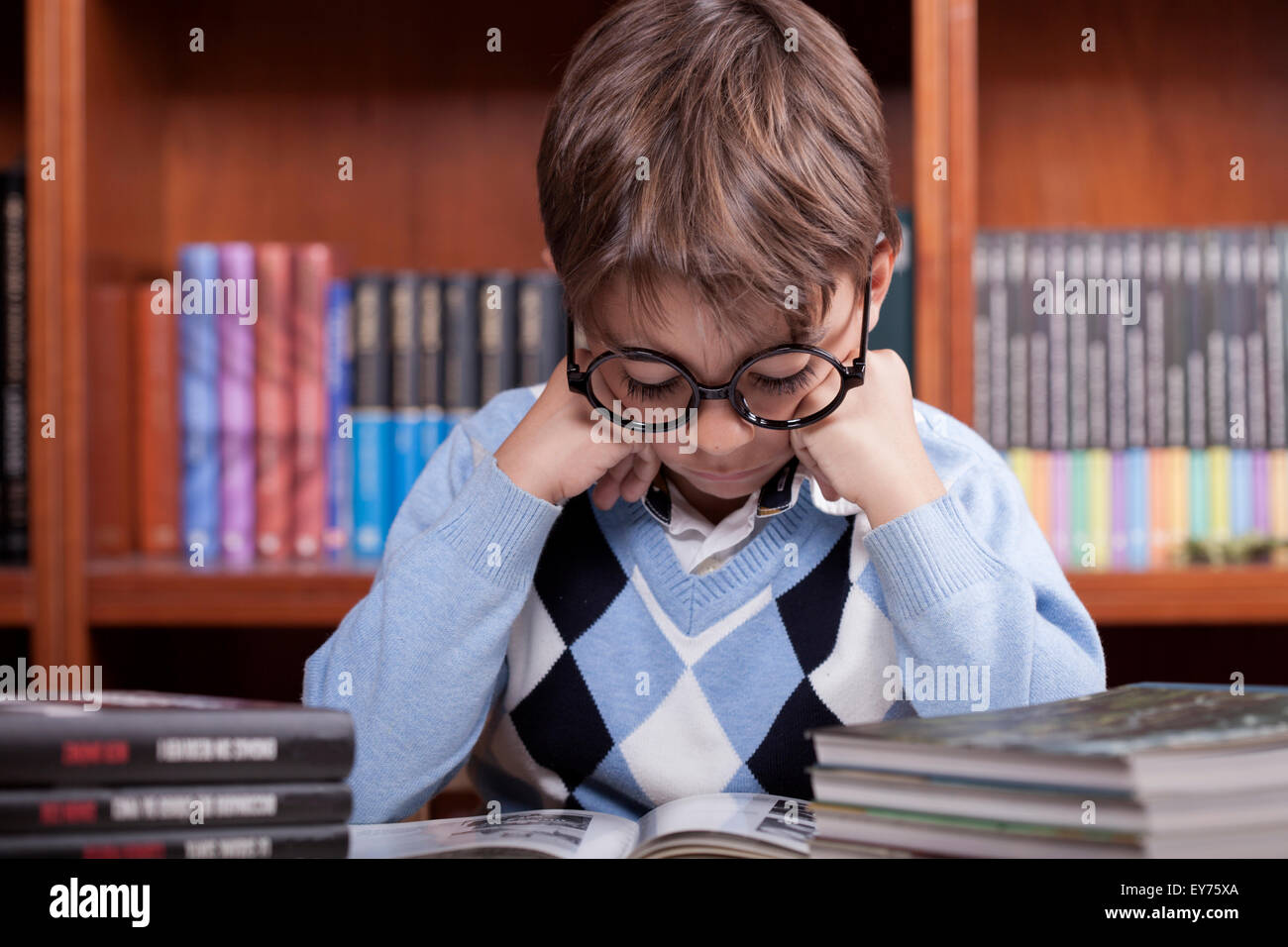 Bored child studying in the library Stock Photo - Alamy