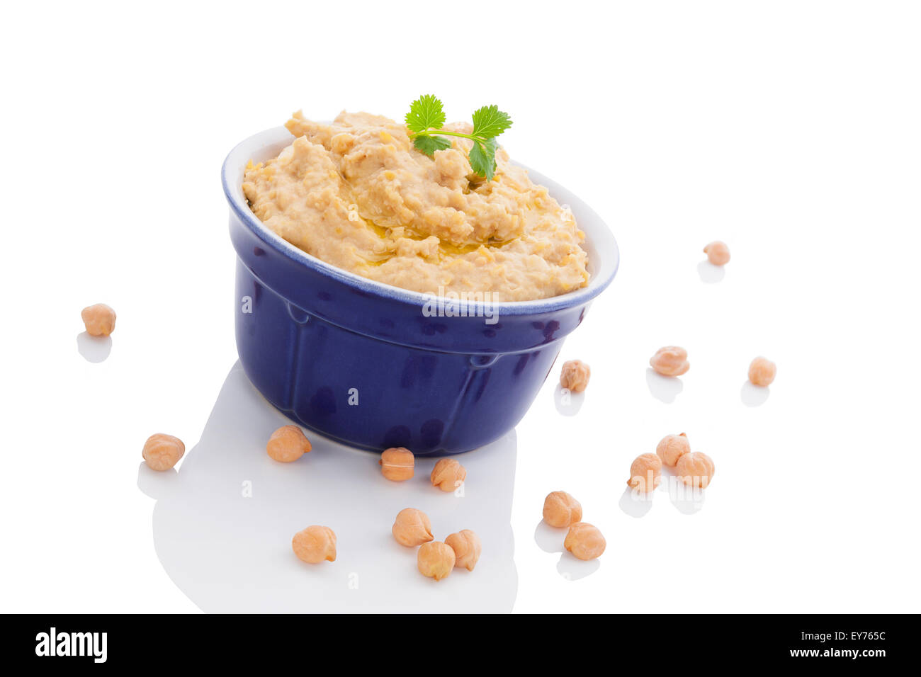 Delicious hummus in ceramic pot and chickpeas isolated on white ...