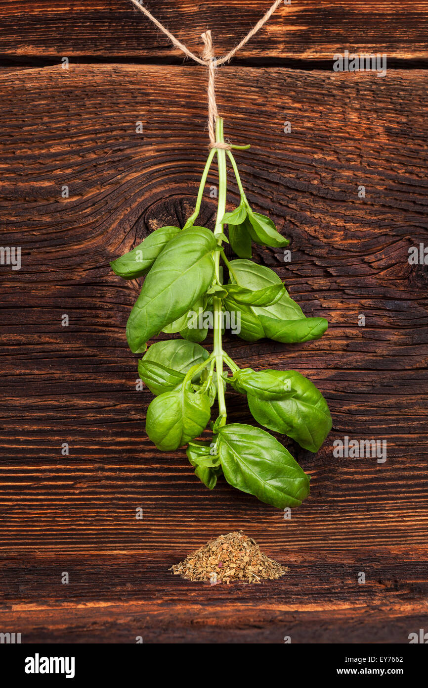 Fresh basil hanging on string and dry basil spice on old vintage wooden ...