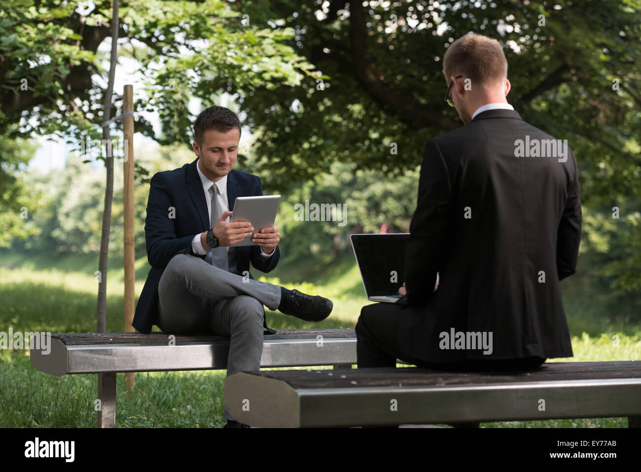 Happy Business Men Using Tablet Pc Outside On A Park Bench Stock Photo ...