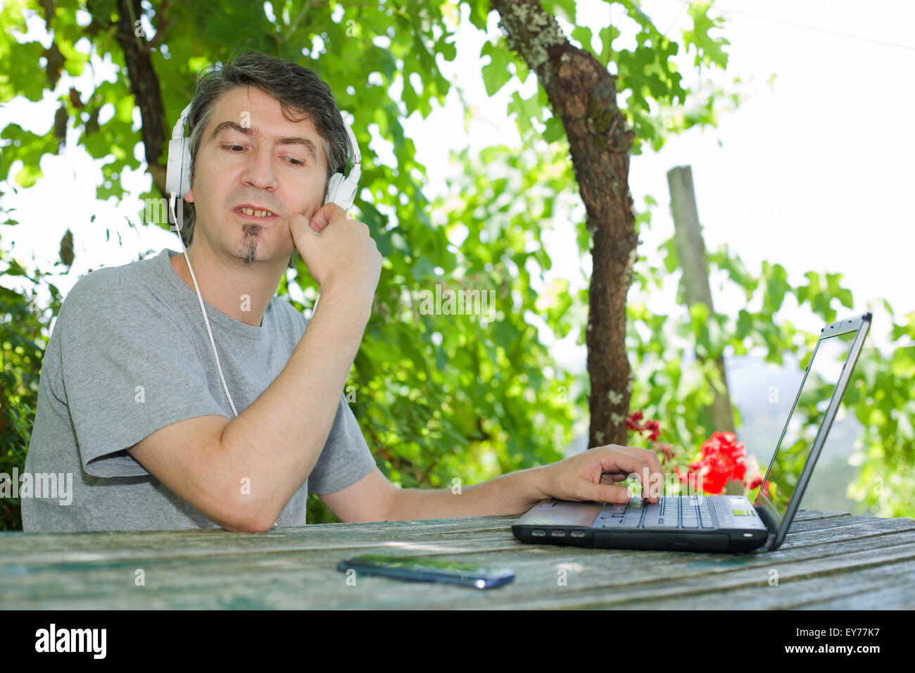 man sitting outdoor working with a laptop Stock Photo - Alamy