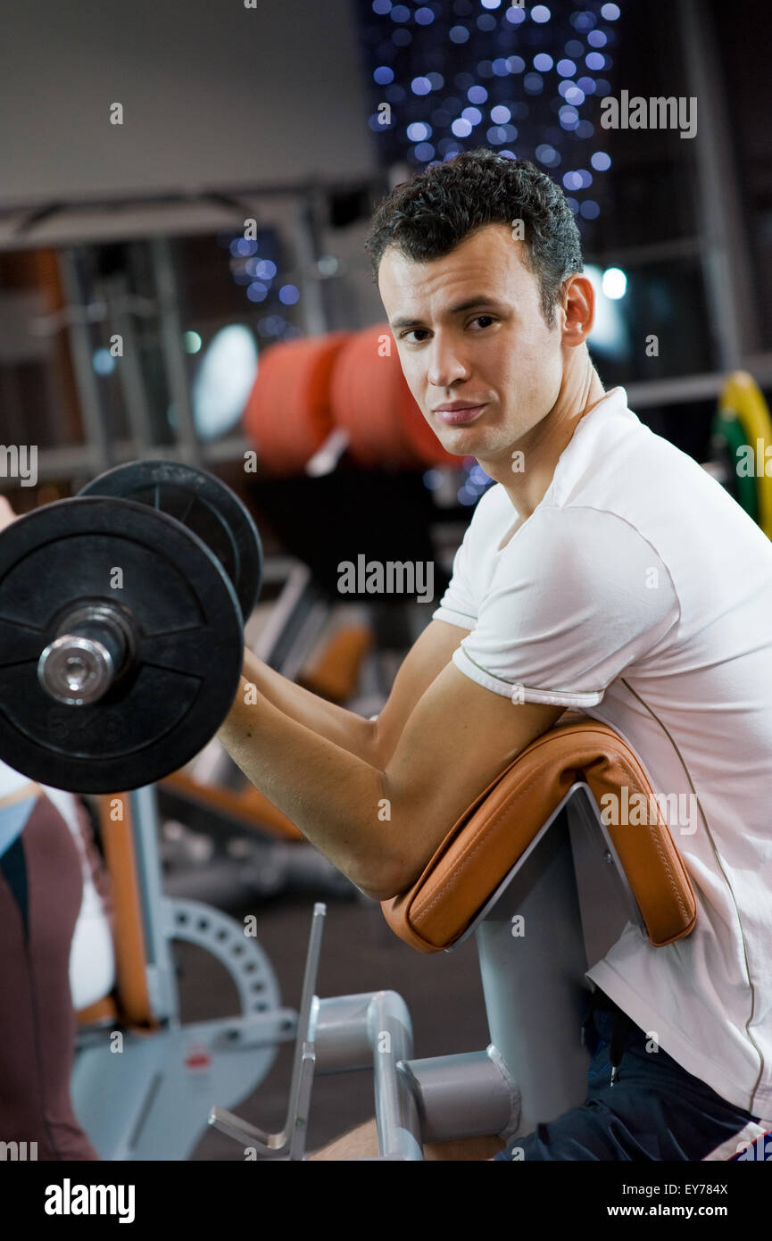 handsome young man lifting weight in a gym Stock Photo - Alamy
