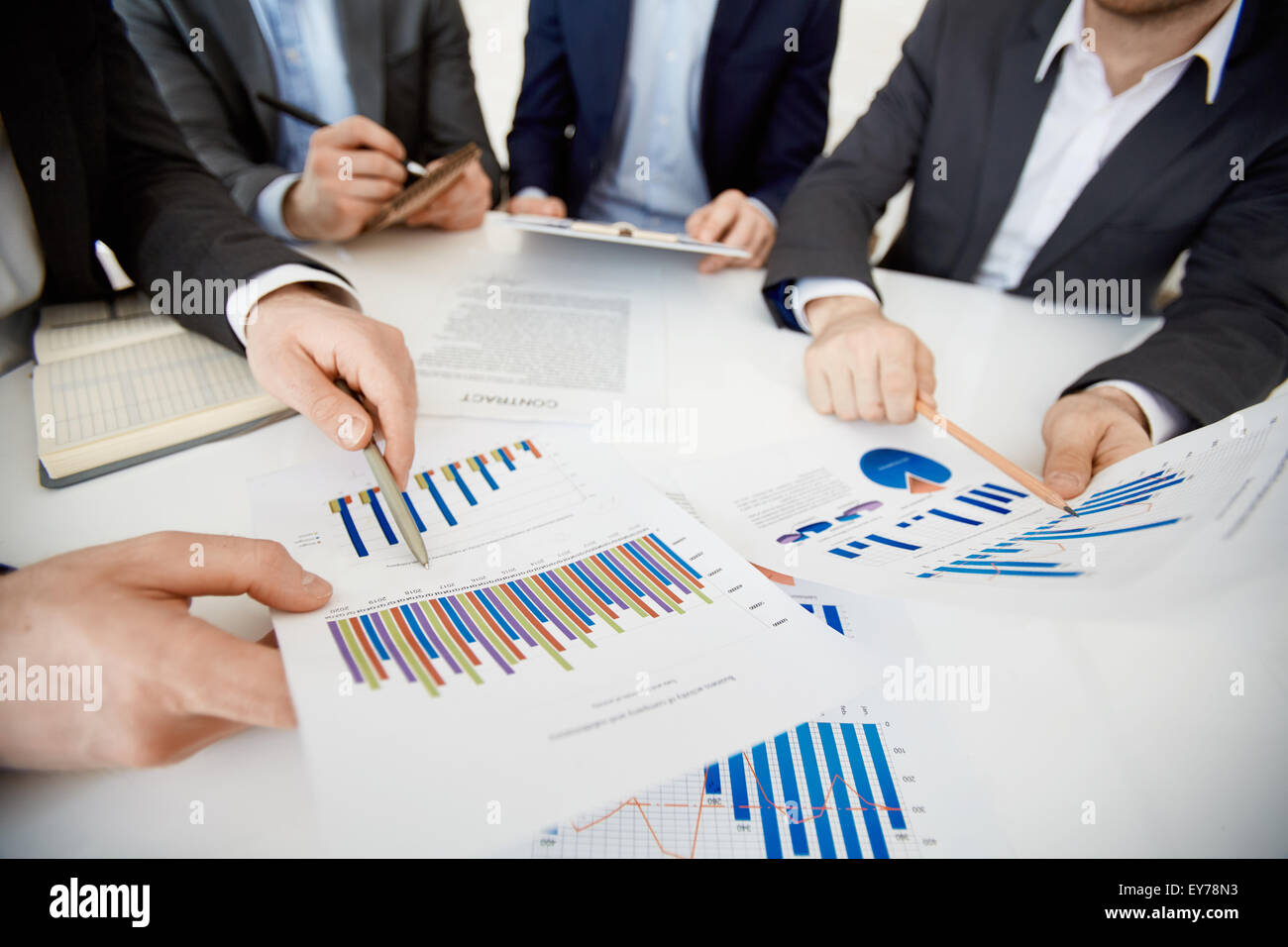 Two co-workers pointing at charts while comparing them Stock Photo - Alamy