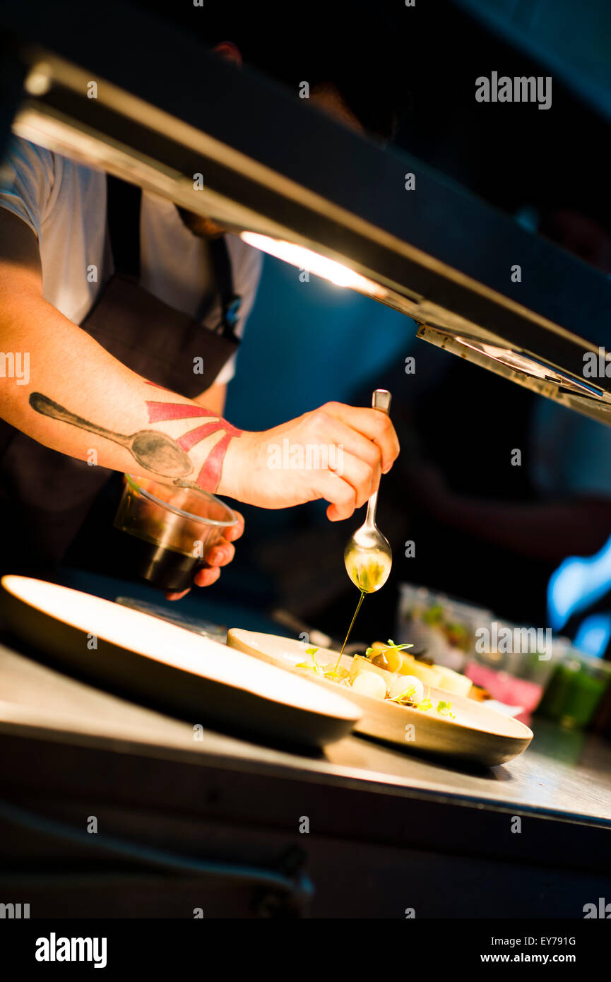 Hospitality and Catering UK: a chef at work in a hotel kitchen pouring ...