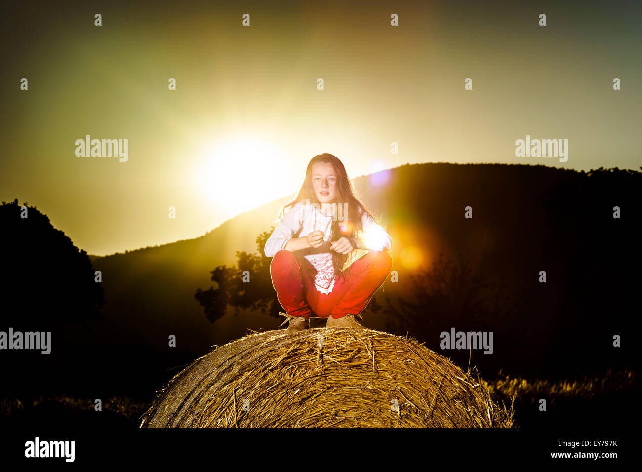 Teenage girl posing at the evening on haystack, sunset colors, Alsace ...