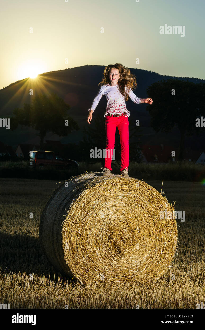 Teenage girl jumping from the haystack, sunset Stock Photo - Alamy