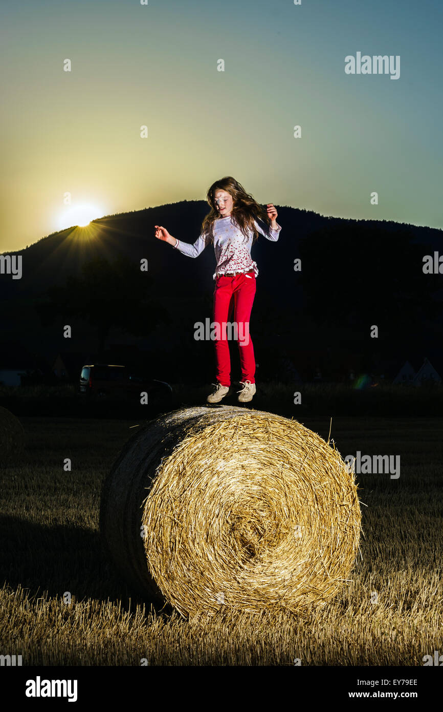 Teenage girl jumping from the haystack, sunset Stock Photo - Alamy