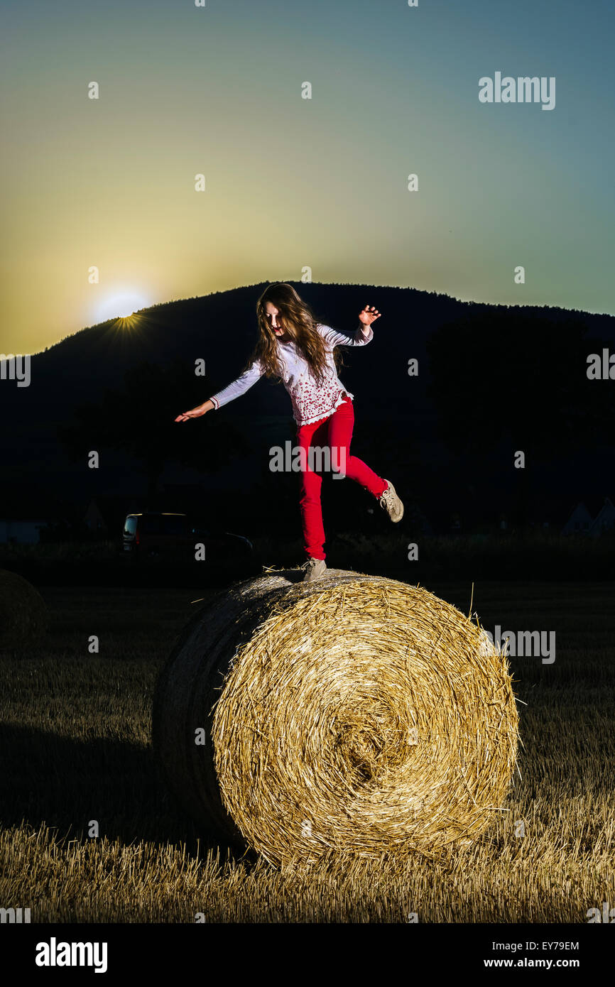 Teenage girl jumping from the haystack, sunset Stock Photo - Alamy