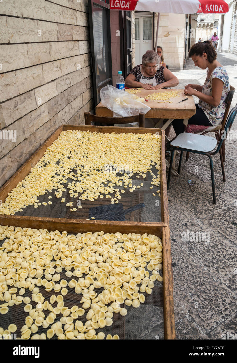 Women making orecchiette, typical puglian pasta, in a sidestreet in ...