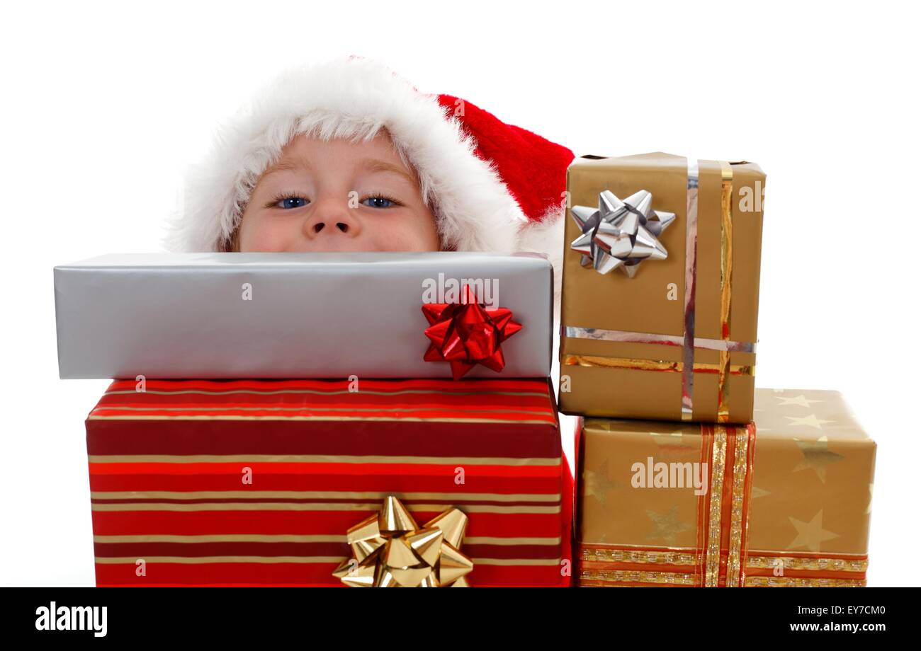 Young boy peeking from behind Christmas presents Stock Photo - Alamy