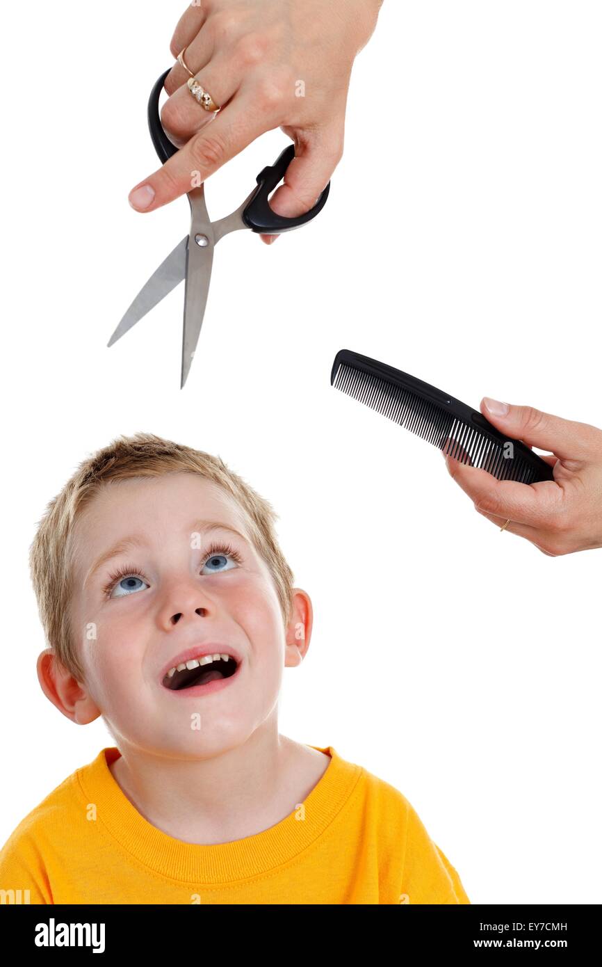Scared young kid looking up to hands holding scissors and comb Stock ...