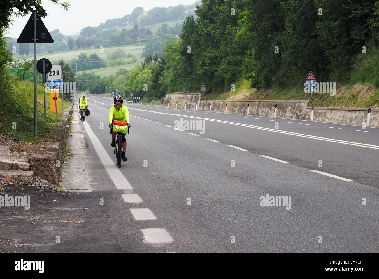 Two touring cyclists riding uphill in the countryside Stock Photo - Alamy