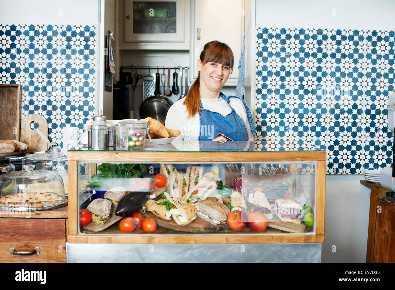 Woman behind counter of coffee shop Stock Photo - Alamy