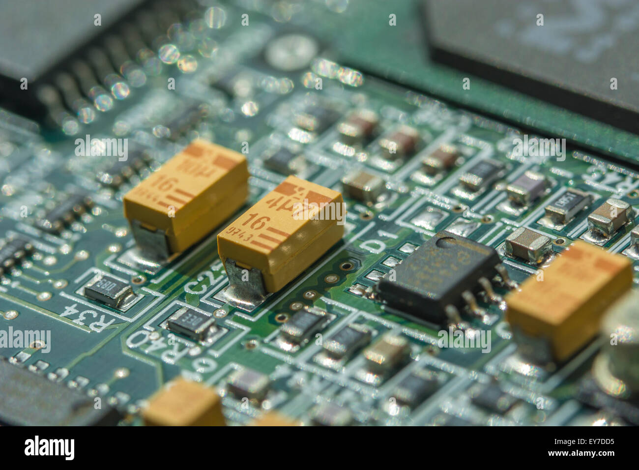 Macro-photo of printed circuit board (PCB) showing yellow tantalum (a ...